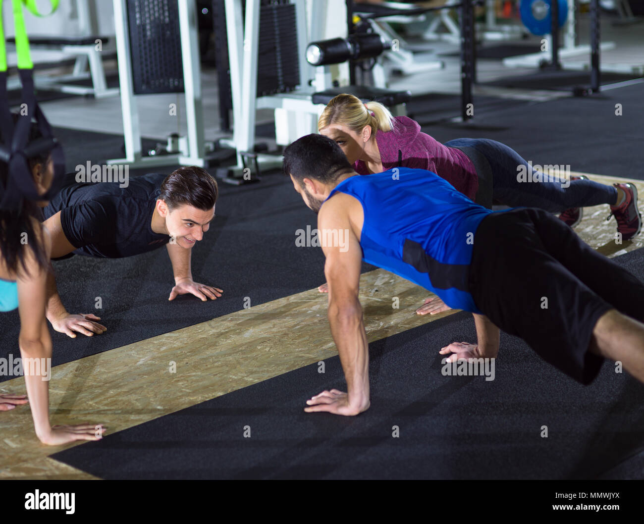 group of young healthy people doing pushups at crossfitness gym Stock ...