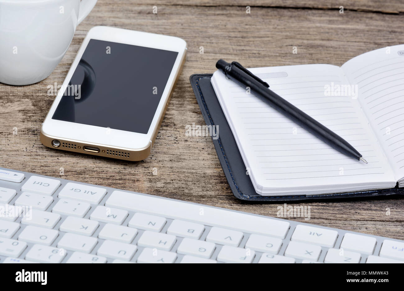 Personal organizer with telephone, keyboard computer on wooden table ...