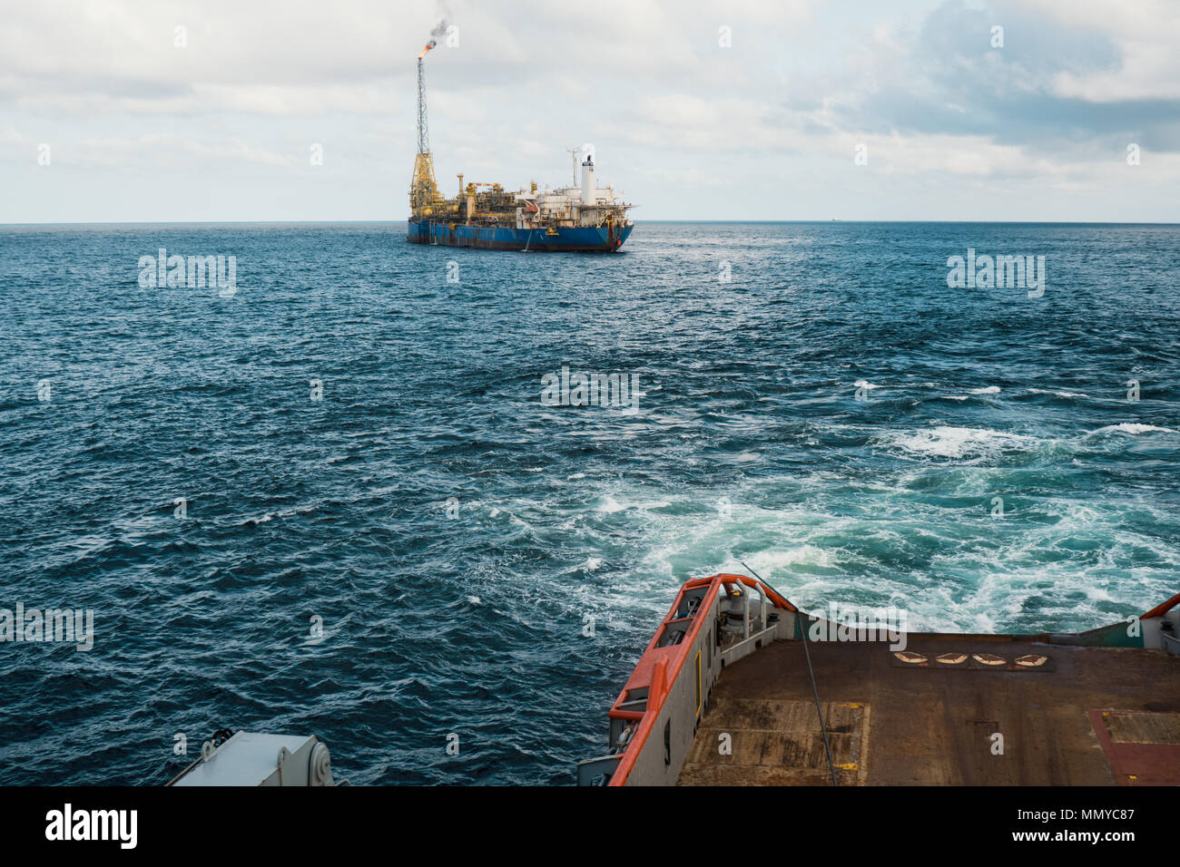 Anchor-handling Tug Supply AHTS vessel towing FPSO tanker. Vessel is ...