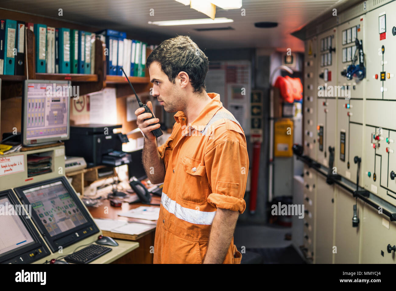 Marine Engineer working on radio communication at Engine Control room ...