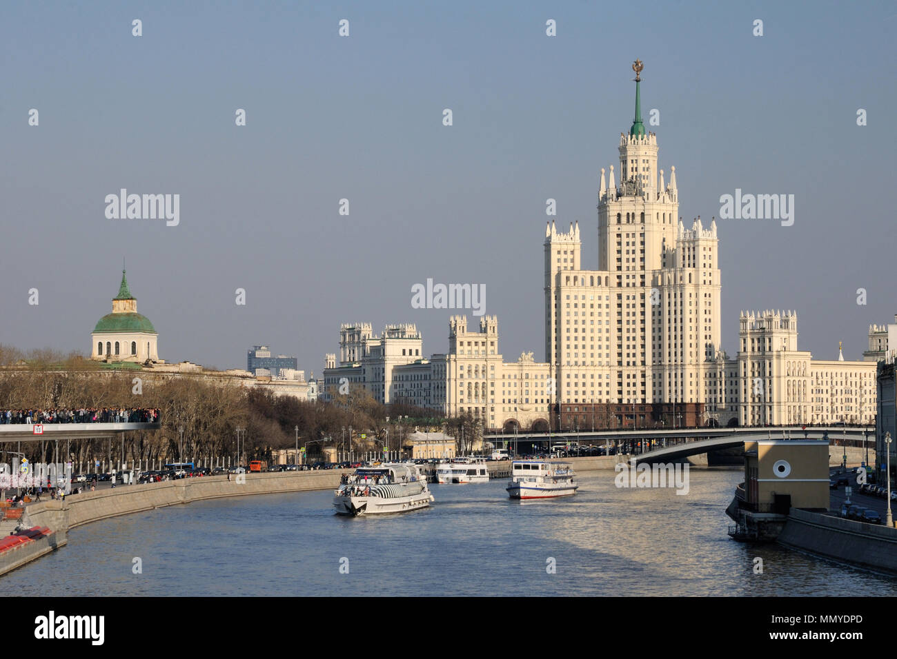Passenger vessels are floating on Moscow River with a Stalin skyscraper ...