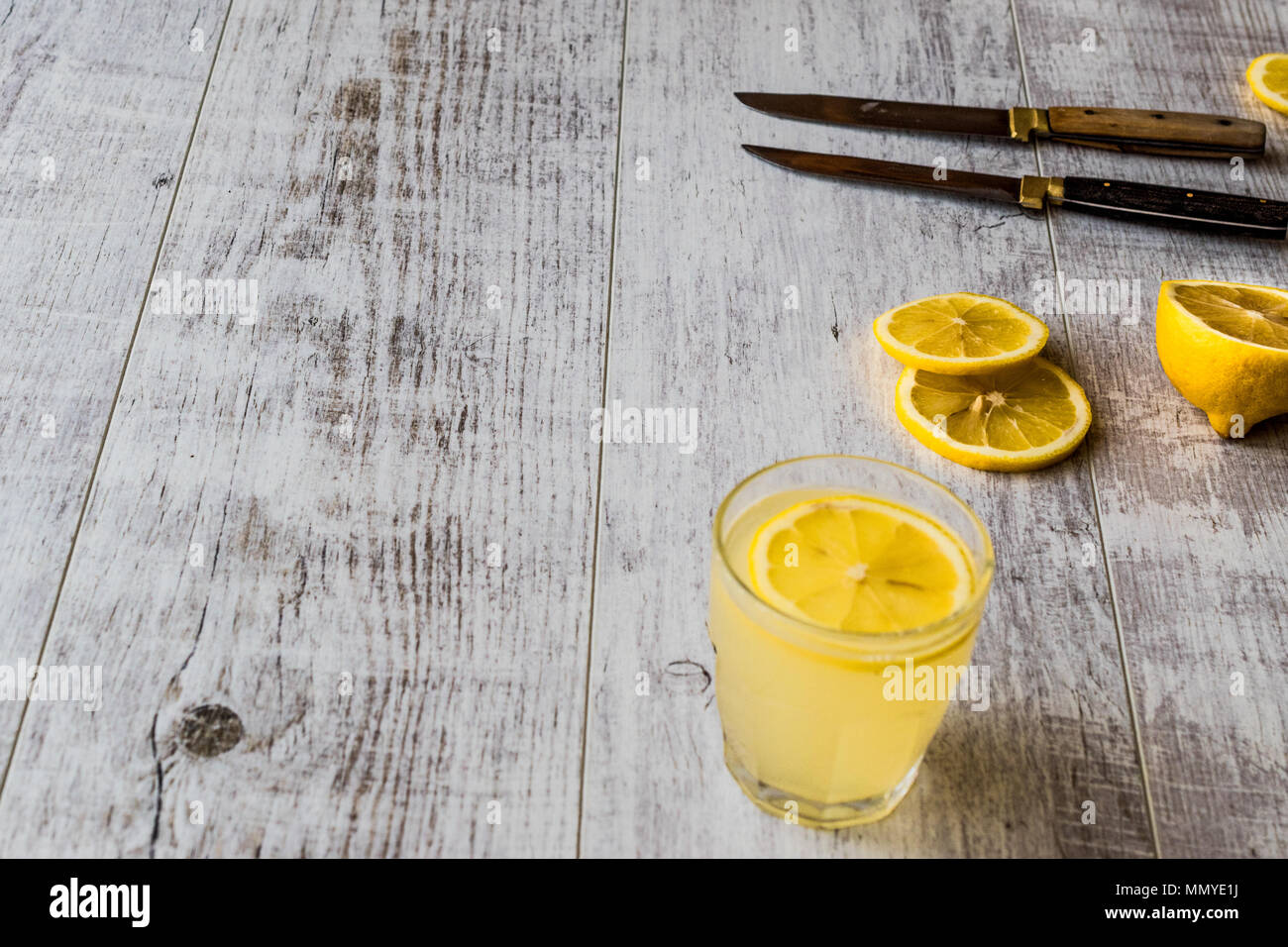 Lemon Liqueur Limoncello with lemon on white wooden surface. Beverage ...