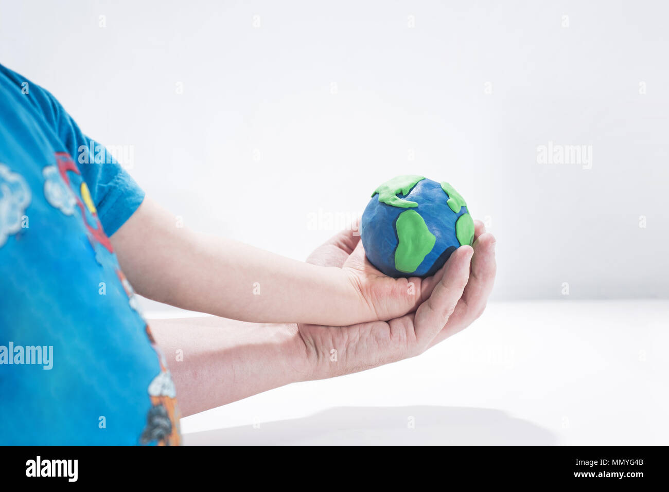 Small Earth model with human hands. Abstract composition of peace Stock ...