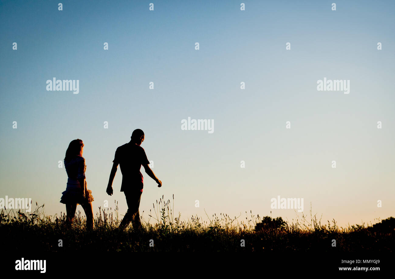 Young couple walking on sunset Stock Photo - Alamy
