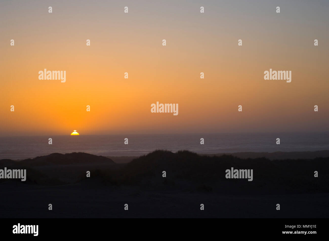 The sun drops below the line of the Pacific Ocean in Philo, California ...