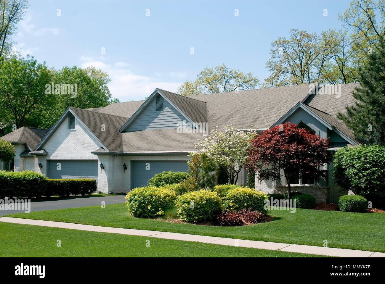 Beautiful white brick ranch home featuring beautiful landscaping Stock ...