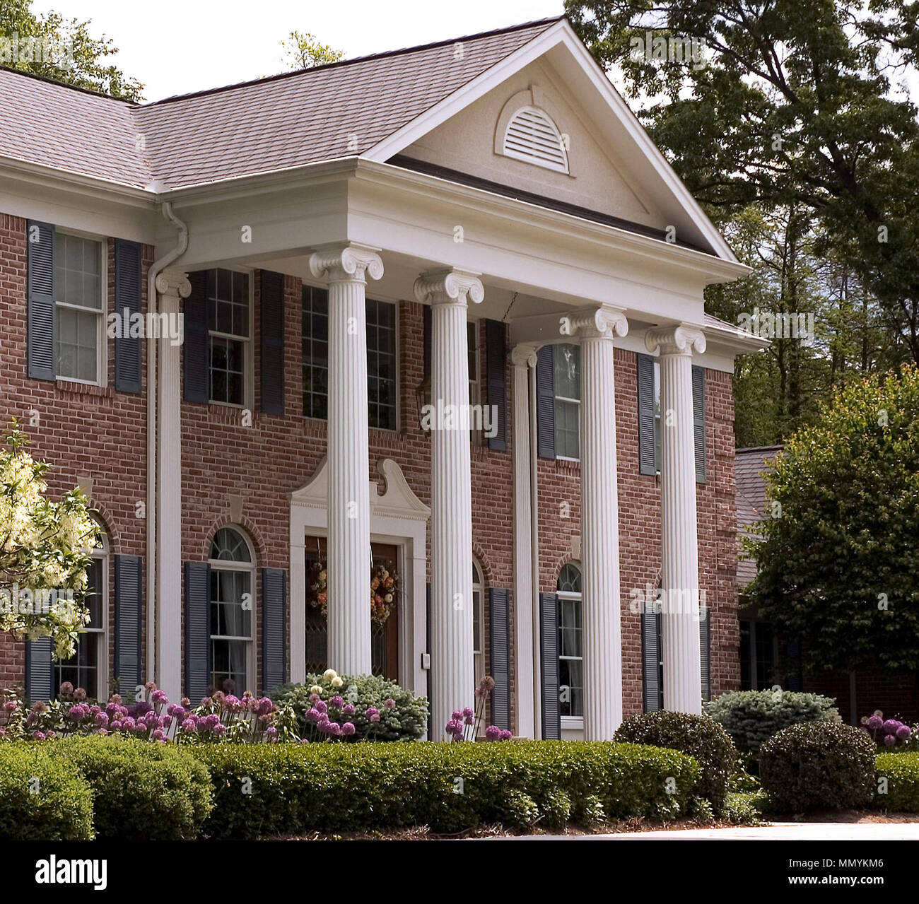 A close-up of an expensive house featuring soaring columns and lots of ...