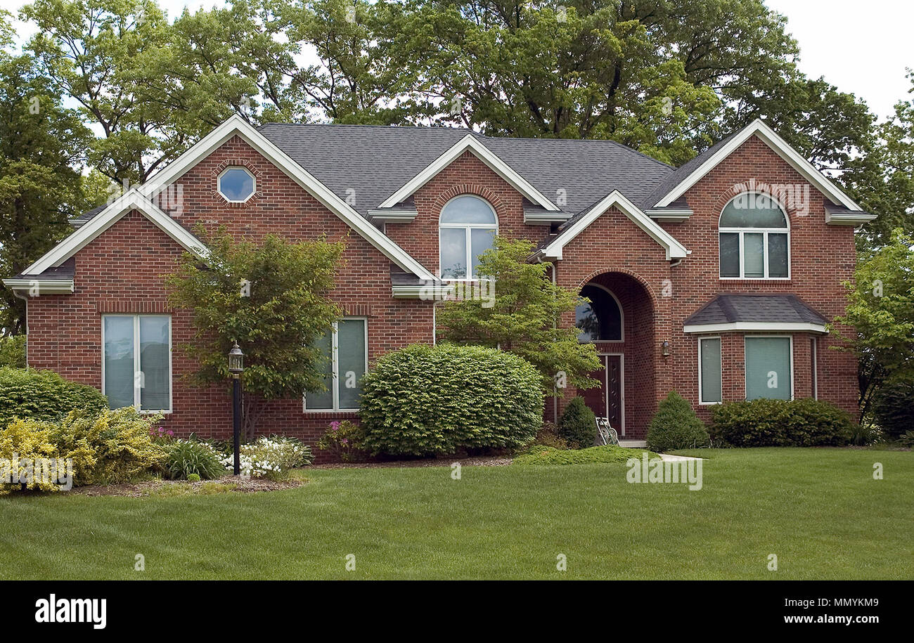 Brick home featuring five roof peaks Stock Photo - Alamy
