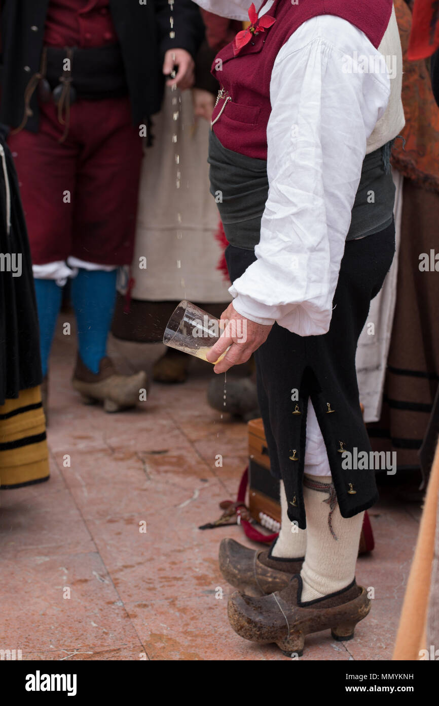 A man wearing traditional costume is pouring a bottle of cider Stock ...