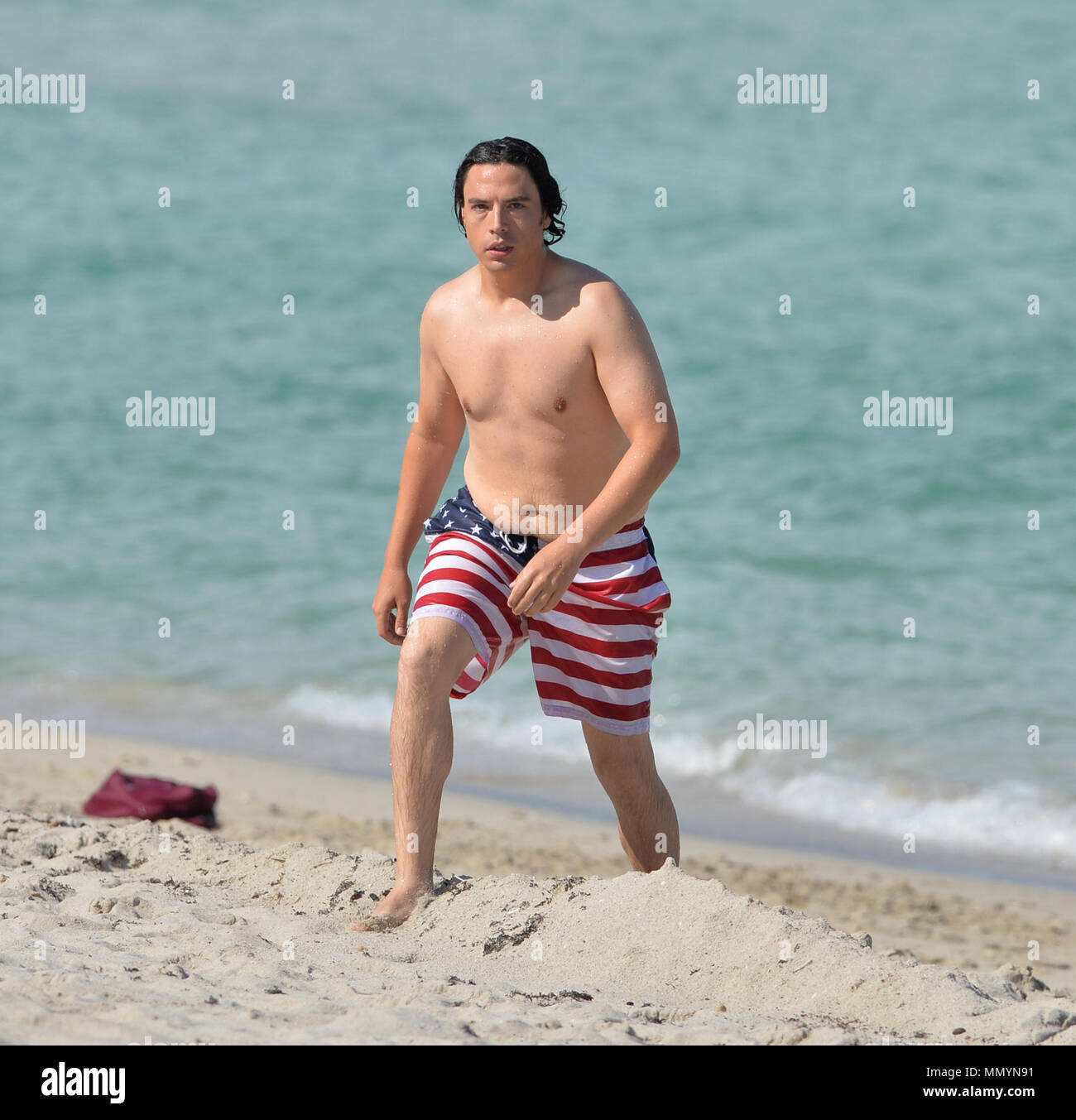 MIAMI BEACH, FL - MAY 14: Actor Jon Bass goes for a swim wearing ...