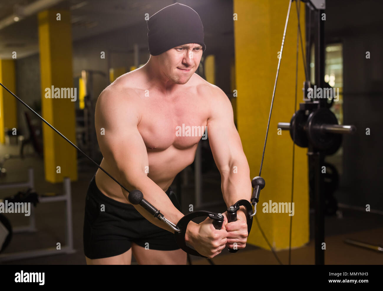 Strong muscular bodybuilder doing exercise in the gym. Fitness training ...