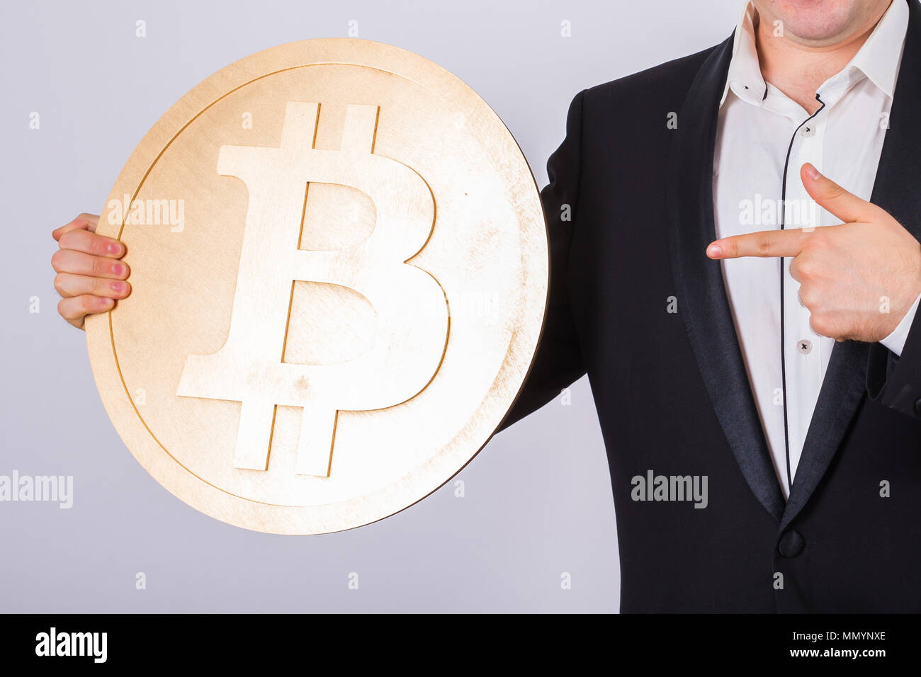 Close up of man holding big bitcoin on white background Stock Photo - Alamy