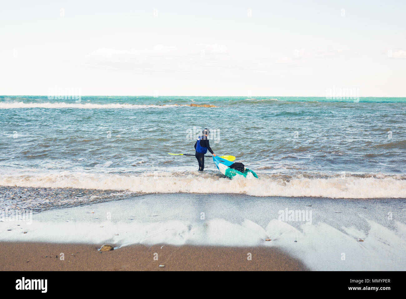 Man carrying his kayak along the shore Stock Photo - Alamy