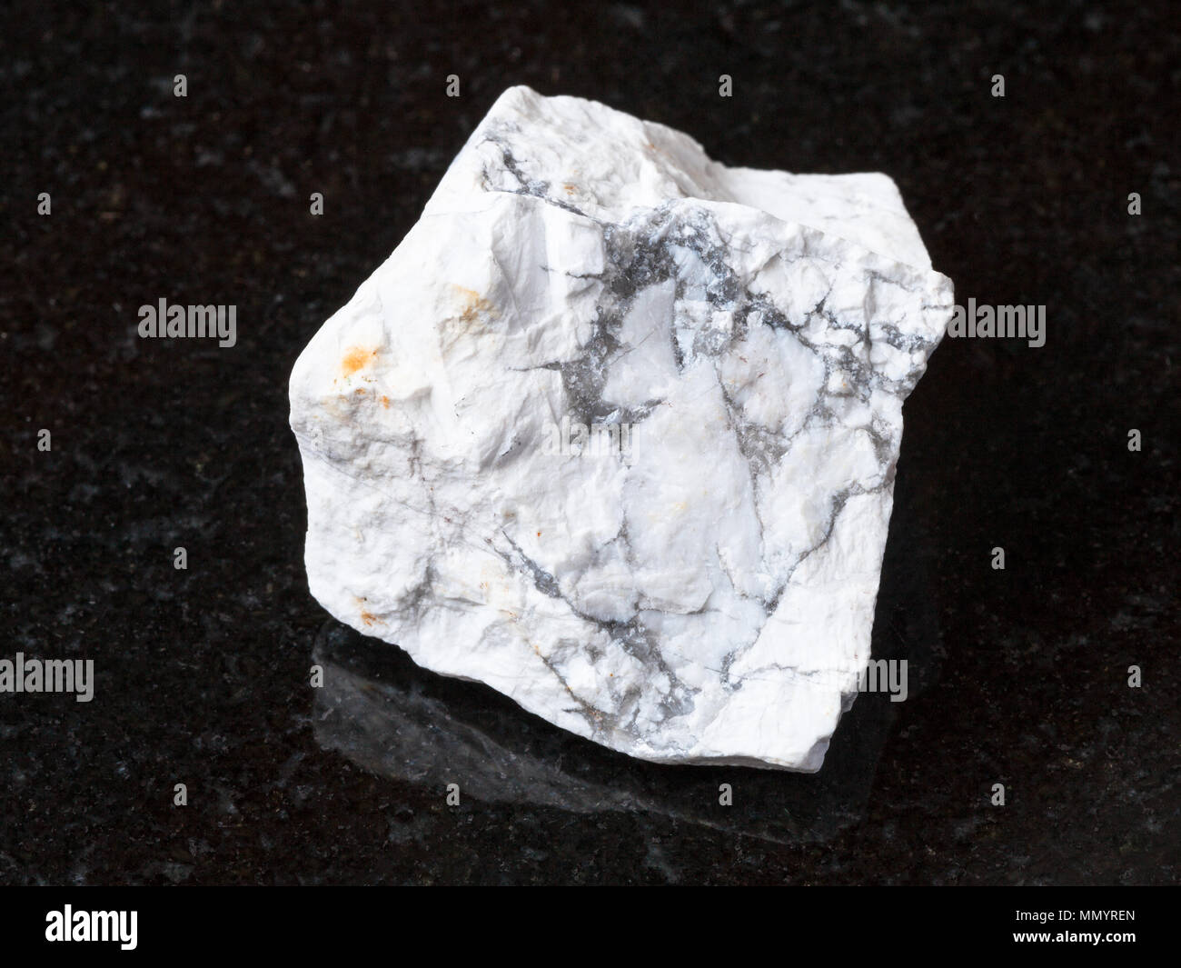 macro shooting of natural rock specimen - rough Howlite stone on black ...