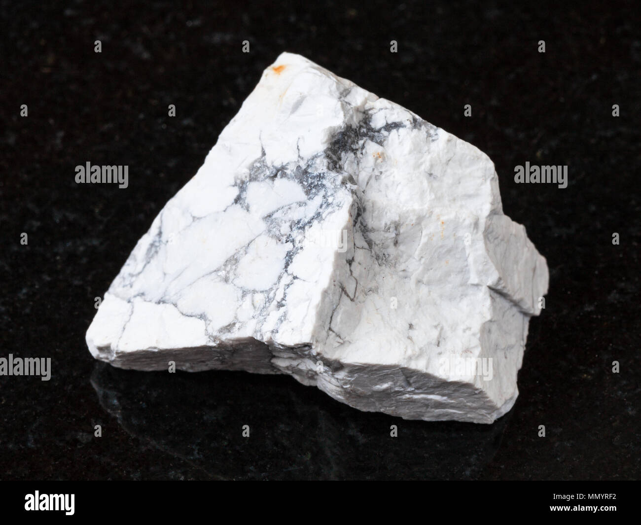 macro shooting of natural rock specimen - white Howlite stone on black ...