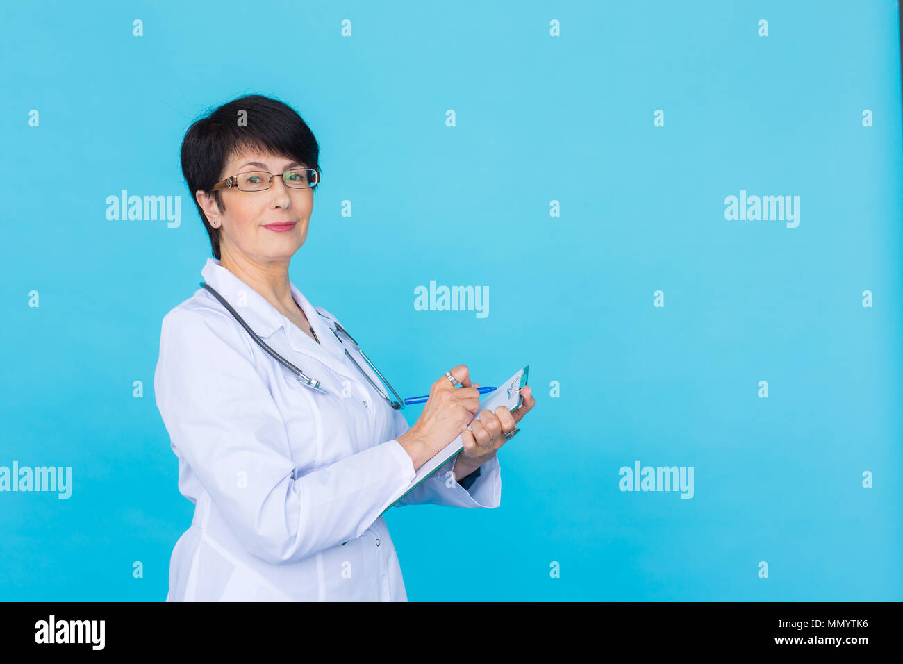 Medical doctor writing prescription over blue background with copy ...