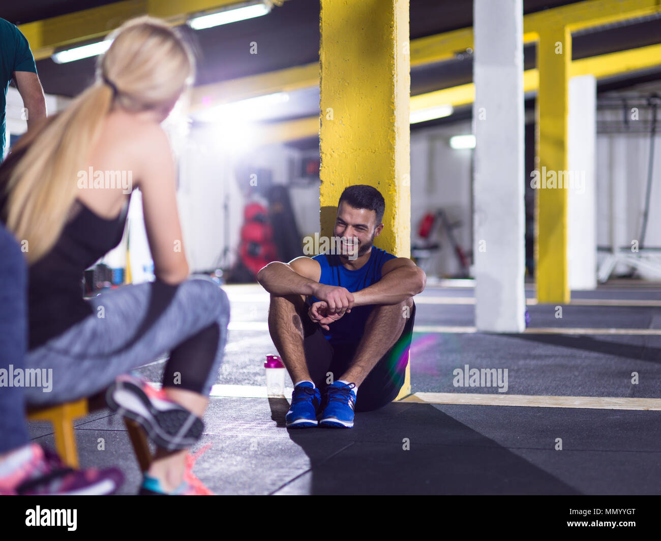 a group of young athletes sitting on the floor and relaxing after ...