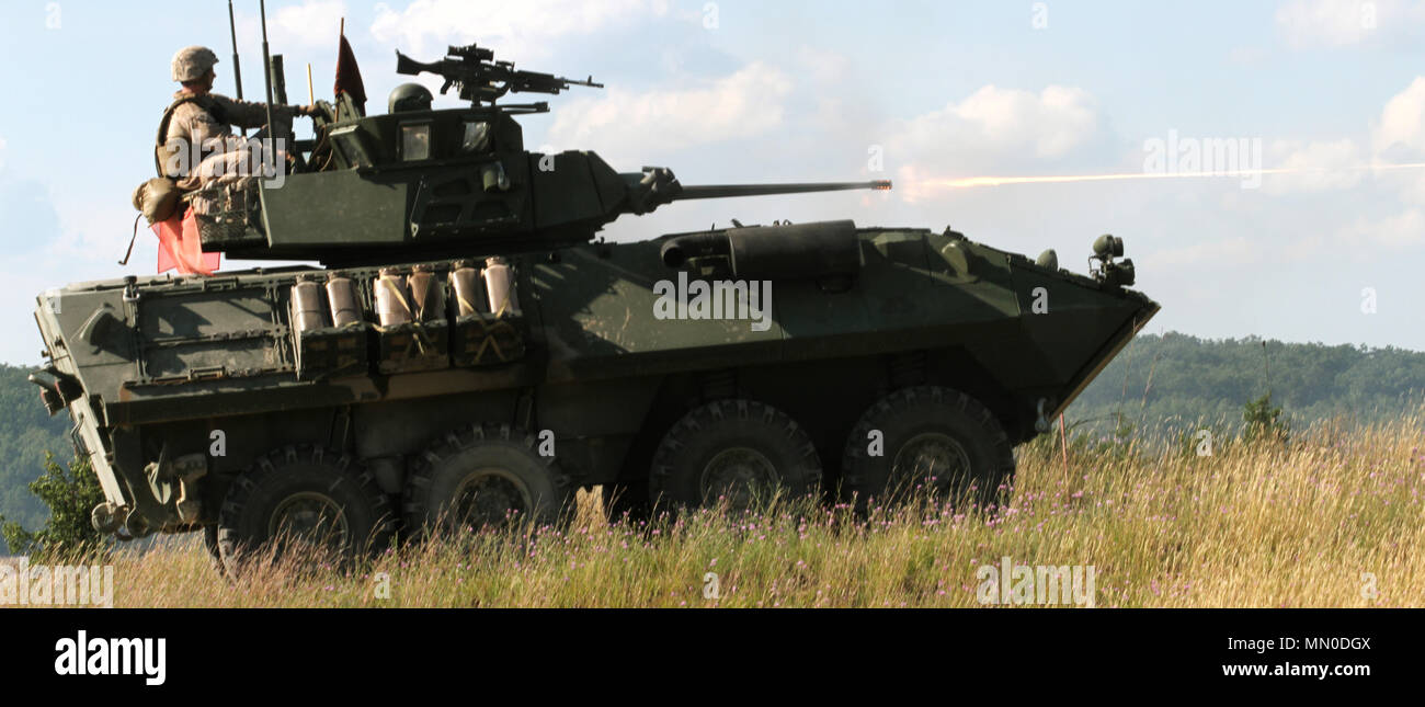 A Light Armor Vehicle (LAV) fires its 25mm chain gun at enemy targets ...
