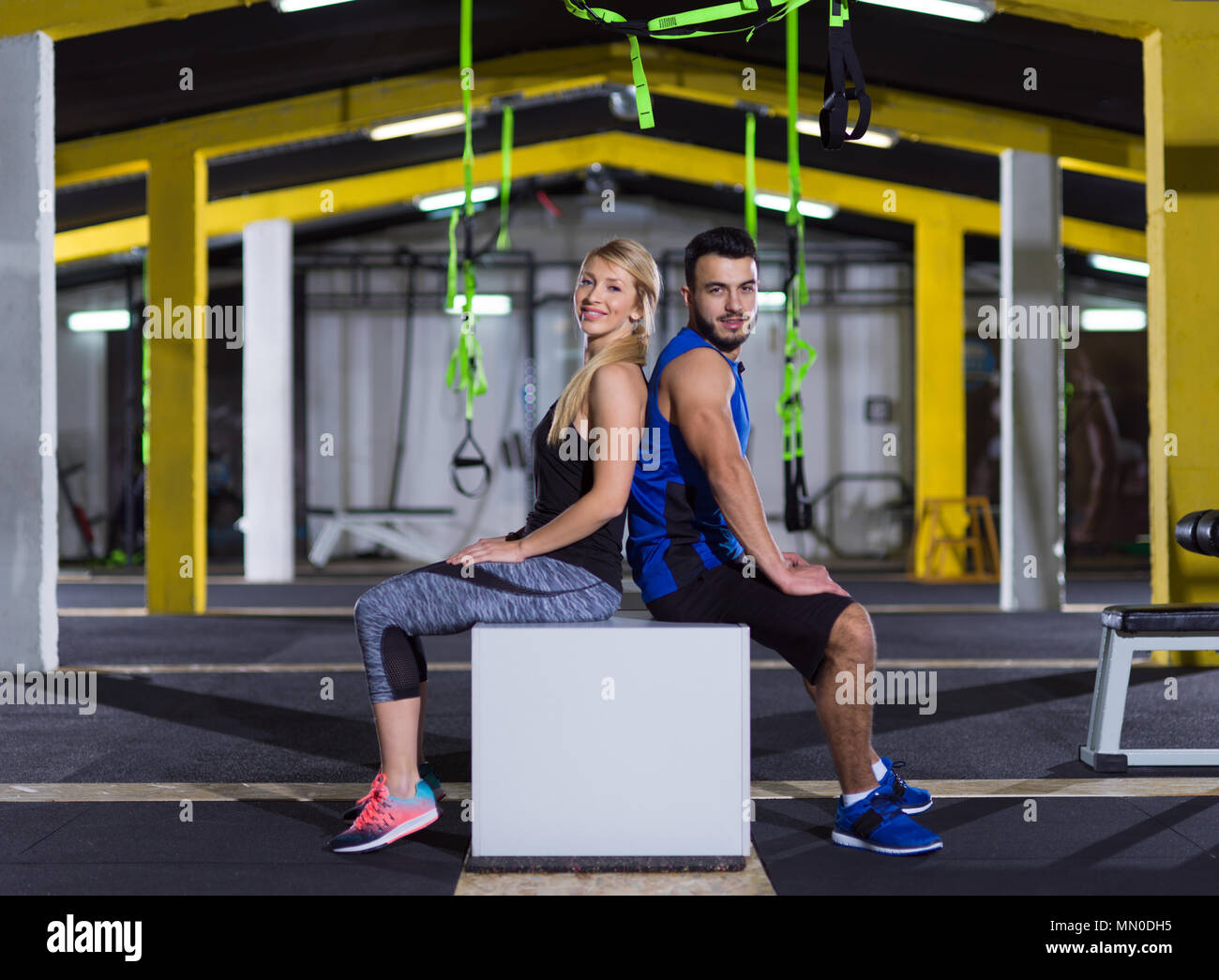 portrait of young healthy athletic people training jumping on fit box ...