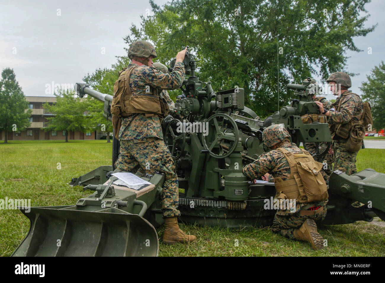 Marines make adjustments to the M777 Light Towed Howitzer during a ...