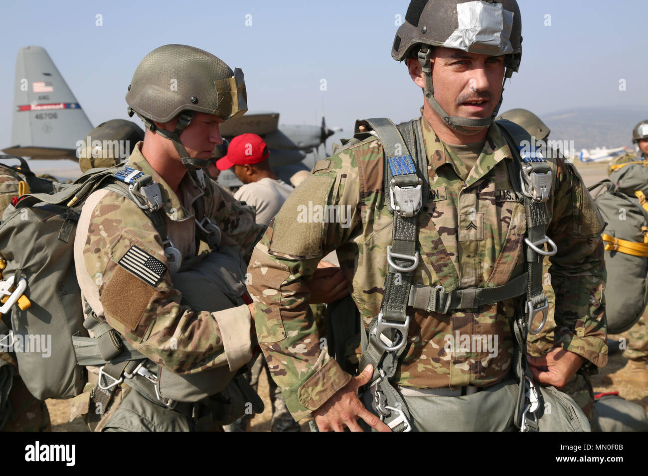 U.S. Army Spc. Ben Brewer, assists Cpl. Jason Zimmerman, both assigned ...