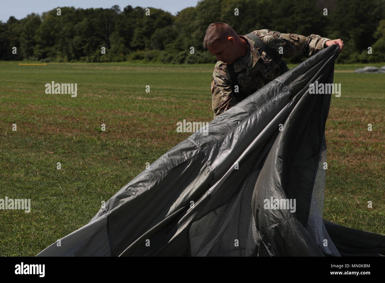 U.S. Army paratrooper packs his MC-6 parachute on Castle drop zone ...