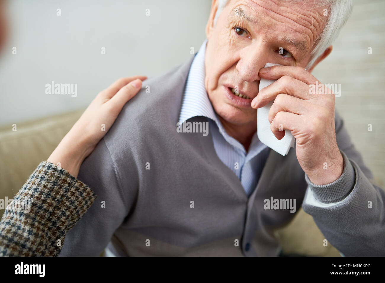 Elderly upset man crying and talking to crop careful nurse giving ...