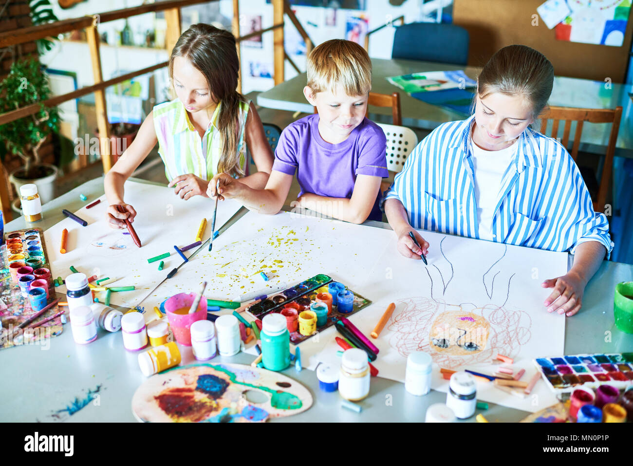 High angle view at group of three children, two girls and one boy ...