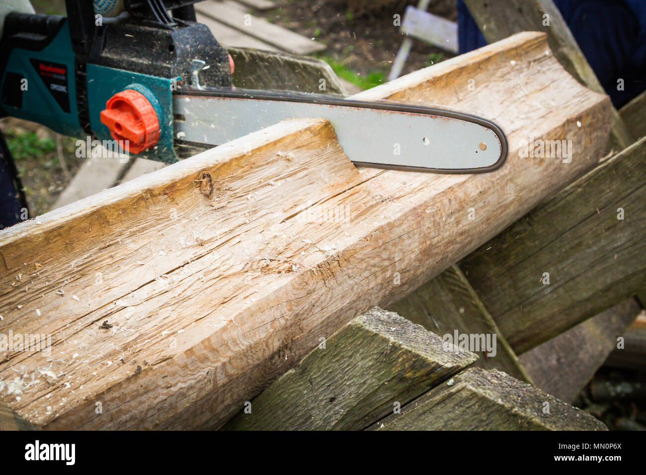 Cut logs for firewood with a chain saw Stock Photo - Alamy