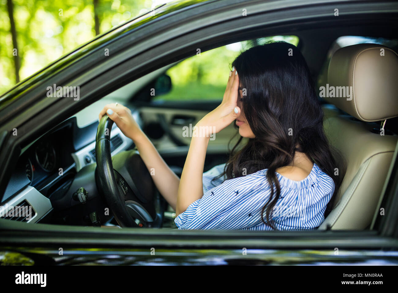 Stressed woman driver with hands on head in her car Stock Photo - Alamy