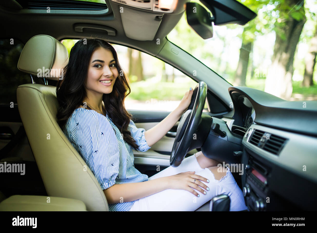 Young beautiful smiling girl driving a car Stock Photo - Alamy