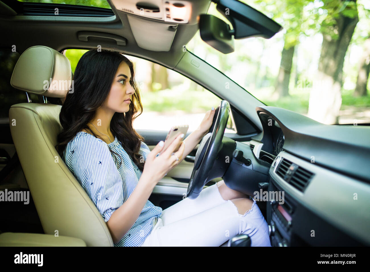 Teenage girl texting on cell phone while driving Stock Photo - Alamy