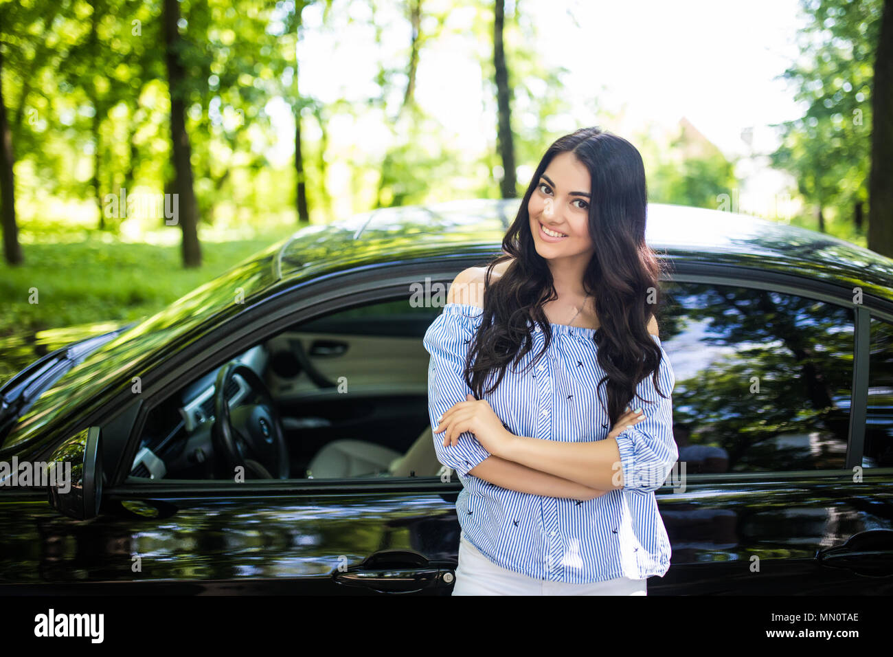 Young woman standing near new car, leaning on auto Stock Photo - Alamy