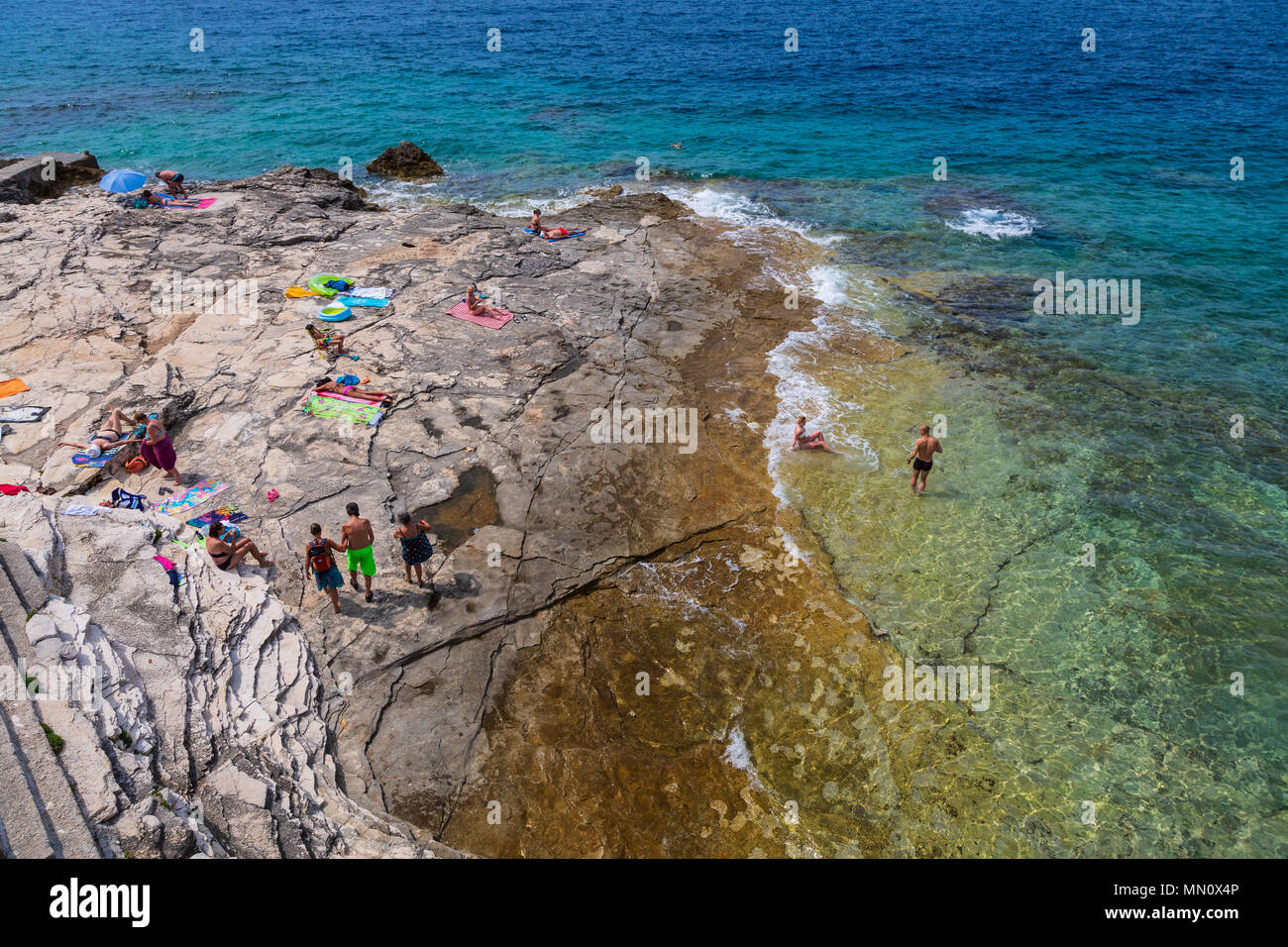 People on a rocky beach in Pula, Punta Verudela, Croatia Stock Photo ...