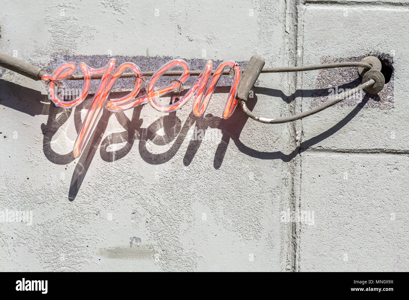 red neon sign that says open in script Stock Photo - Alamy