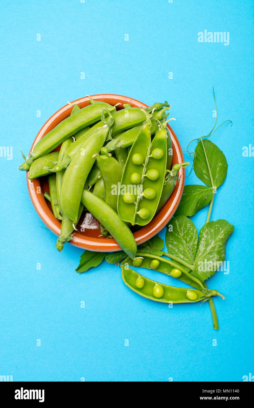 Fresh green ripe sugar snaps, sweet peas in bowl copy space close up on ...