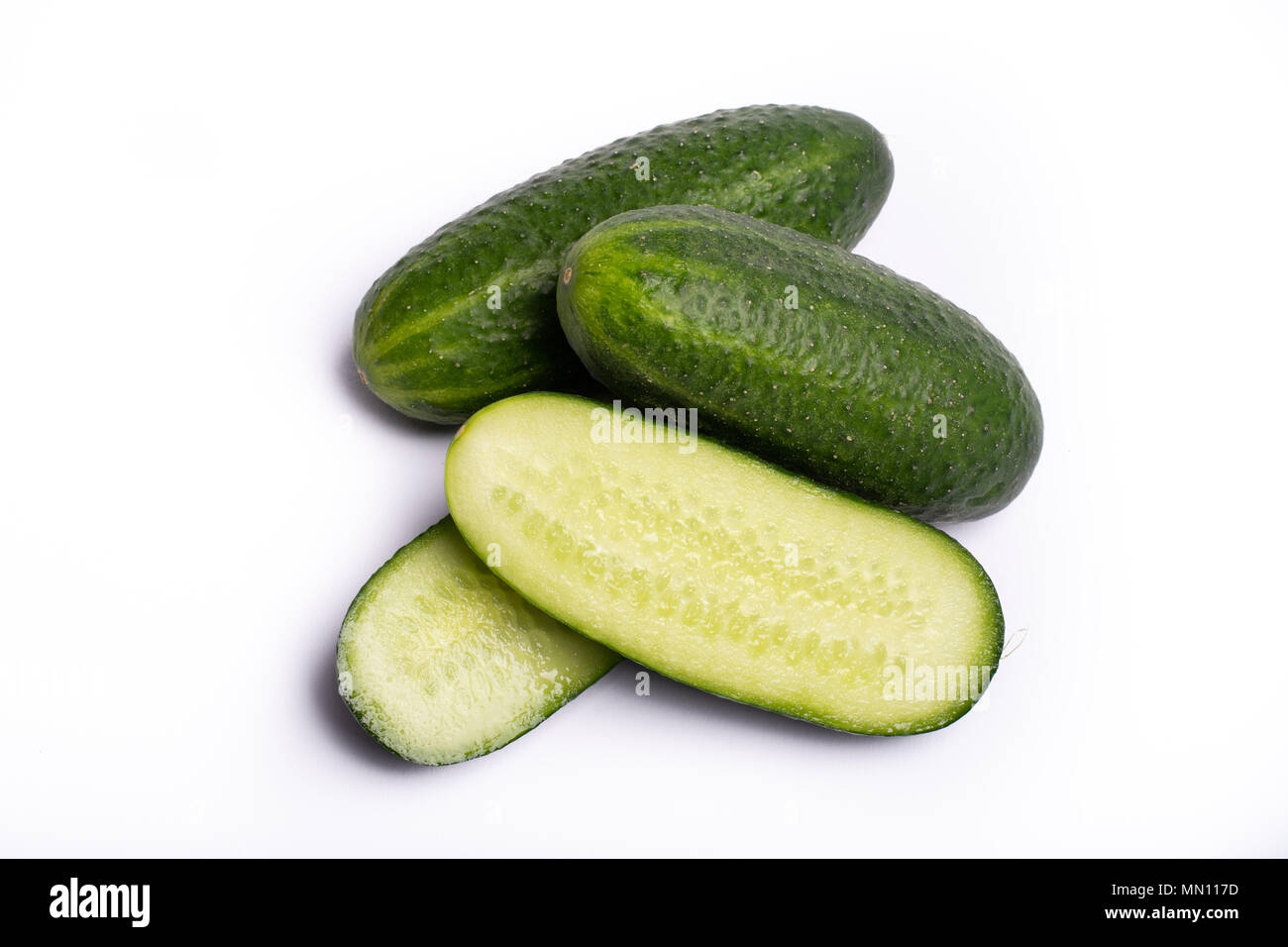 Fresh small green cucumbers whole and sliced close up copy space ...