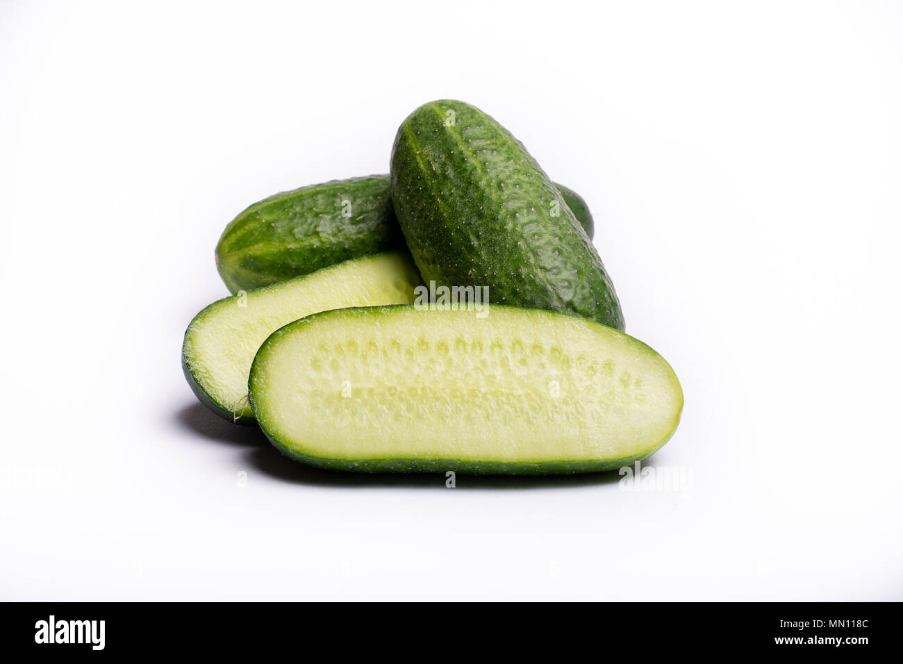 Fresh small green cucumbers whole and sliced close up copy space ...