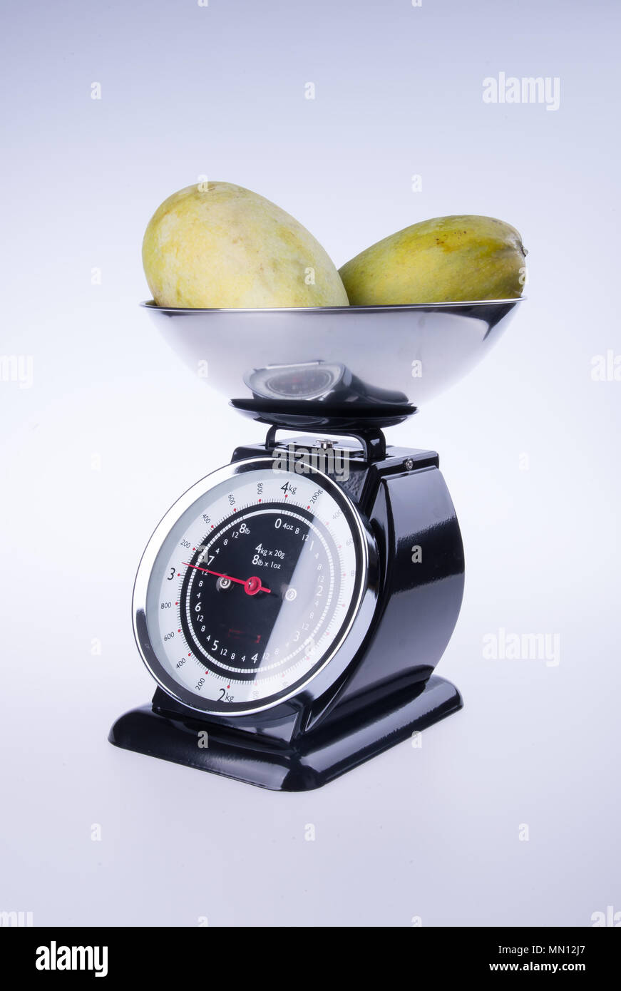 scales for kitchen or kitchen scales with mango Stock Photo - Alamy