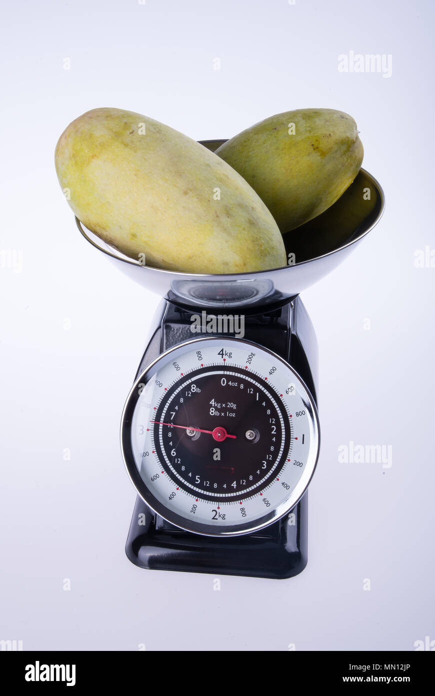 scales for kitchen or kitchen scales with mango Stock Photo - Alamy