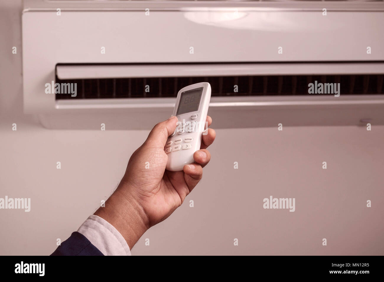 Man turn on air conditioner hi-res stock photography and images - Alamy