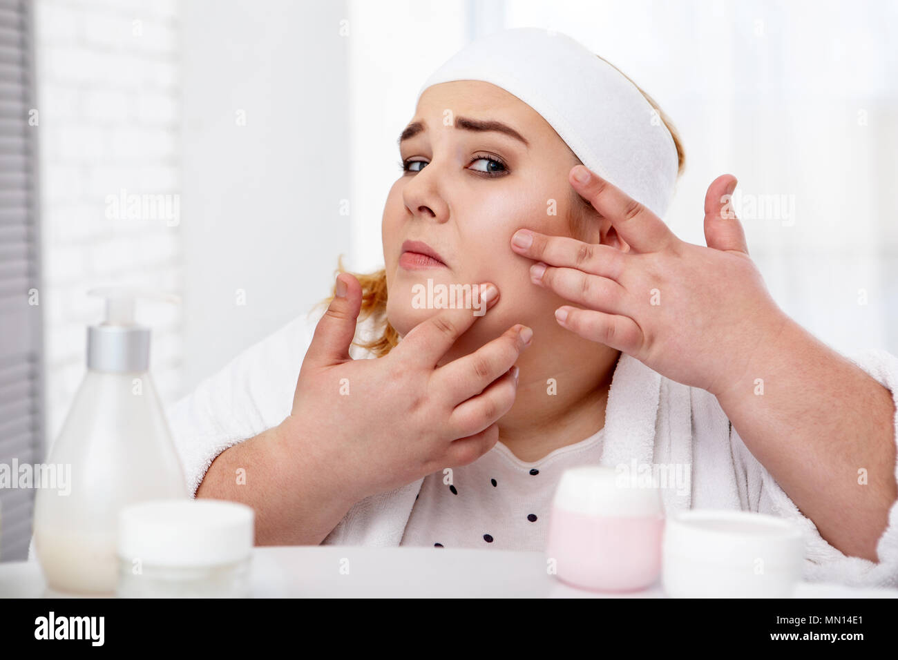 Concerned fat woman popping pimples Stock Photo - Alamy