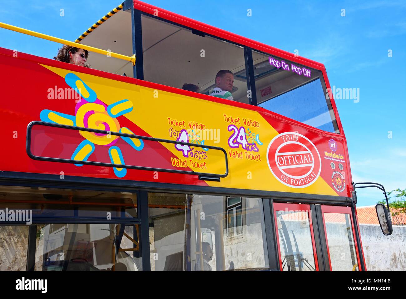 Tourists aboard a red and yellow open topped tour bus, Albufeira ...