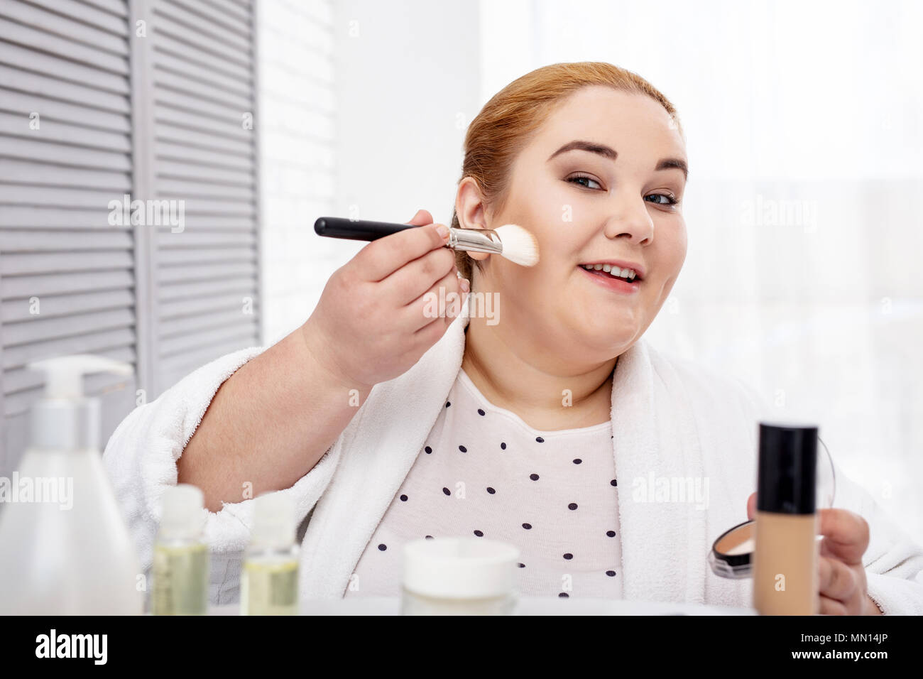 Happy fat woman applying make-up Stock Photo - Alamy
