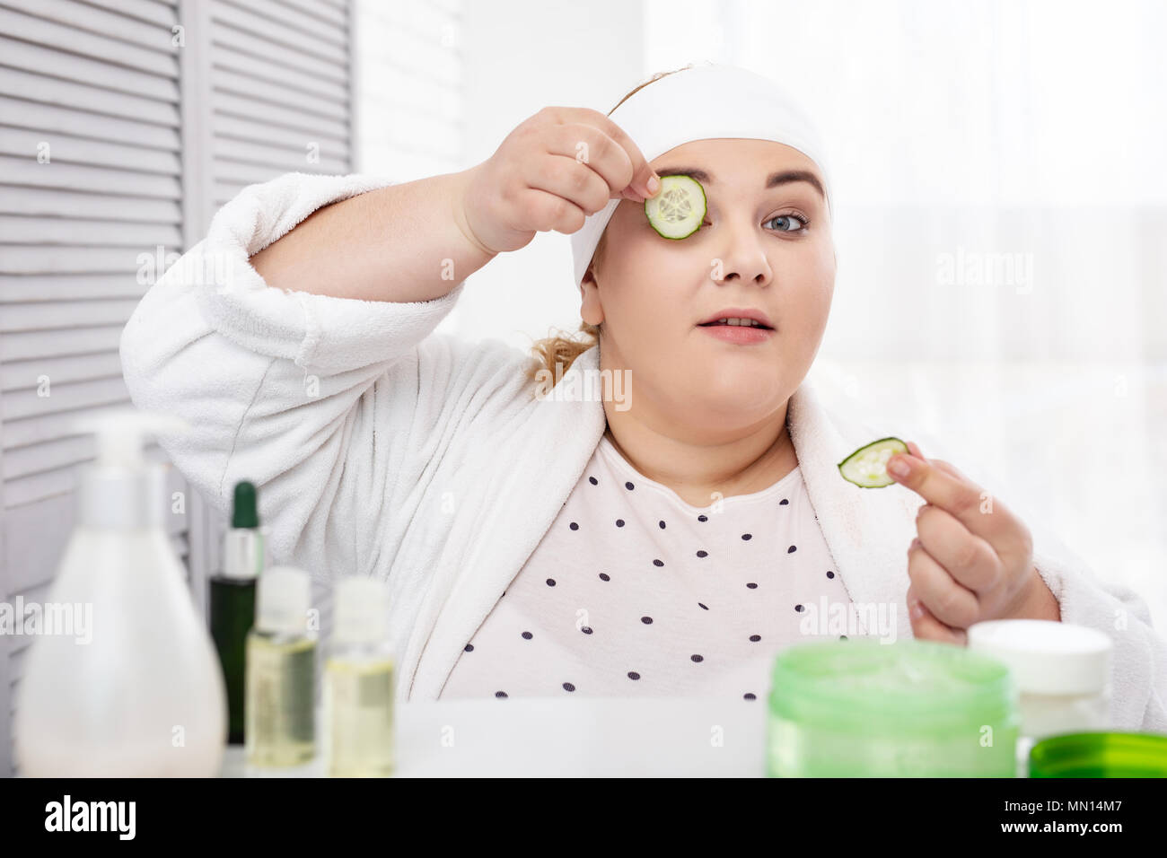 Serious fat woman making a cucumber mask Stock Photo - Alamy