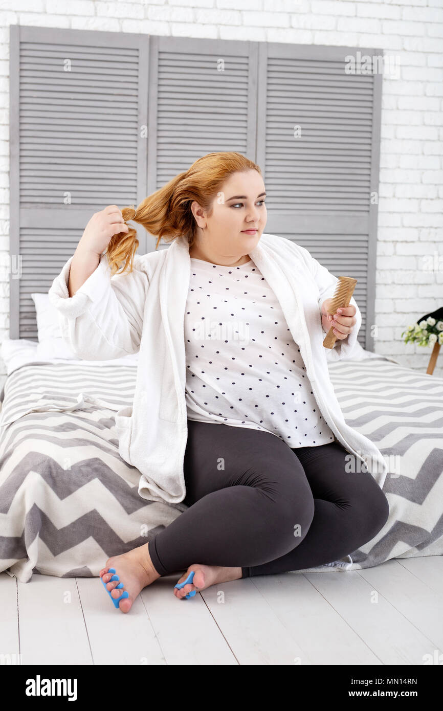 Cheerful stout woman combing her hair Stock Photo - Alamy