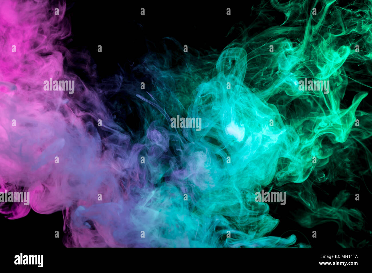 Colorful pink, green and blue smoke on a black isolated background ...