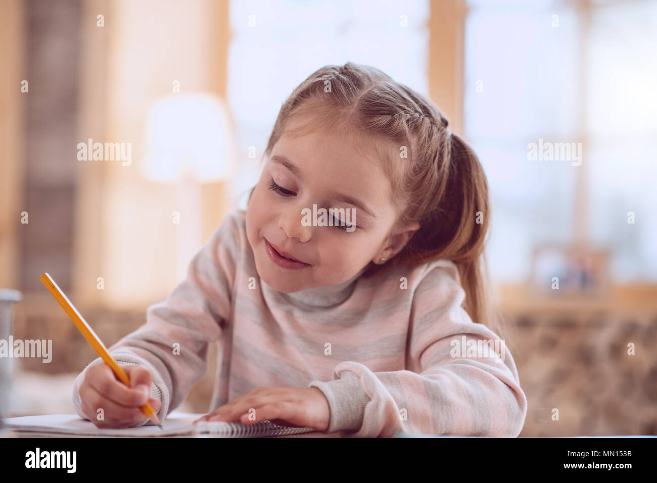 Nice positive girl holding a pencil Stock Photo - Alamy