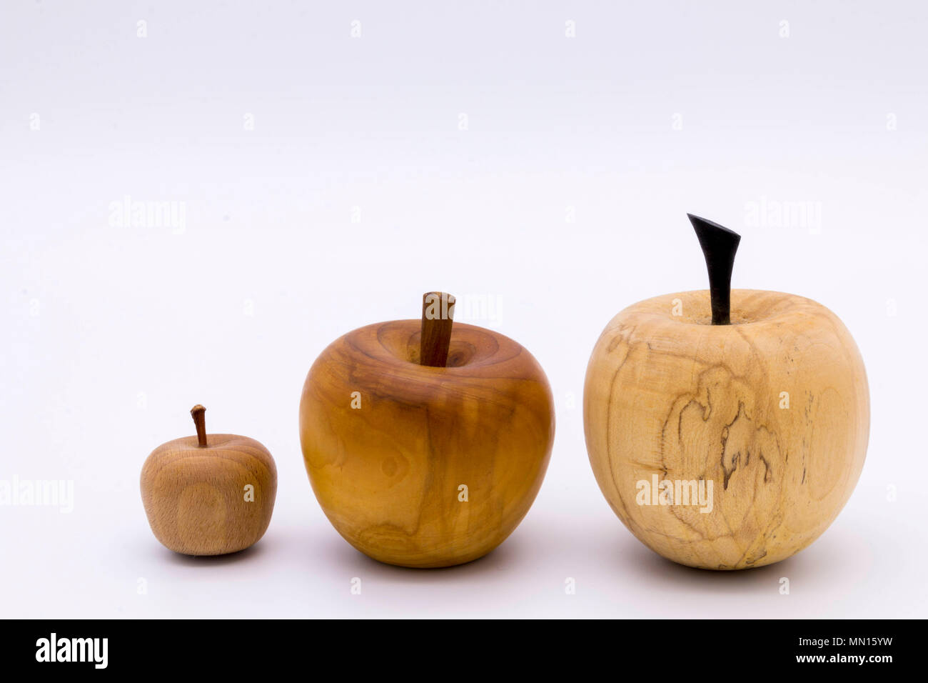 A selection of decorative carved wooden fruit on a white background ...