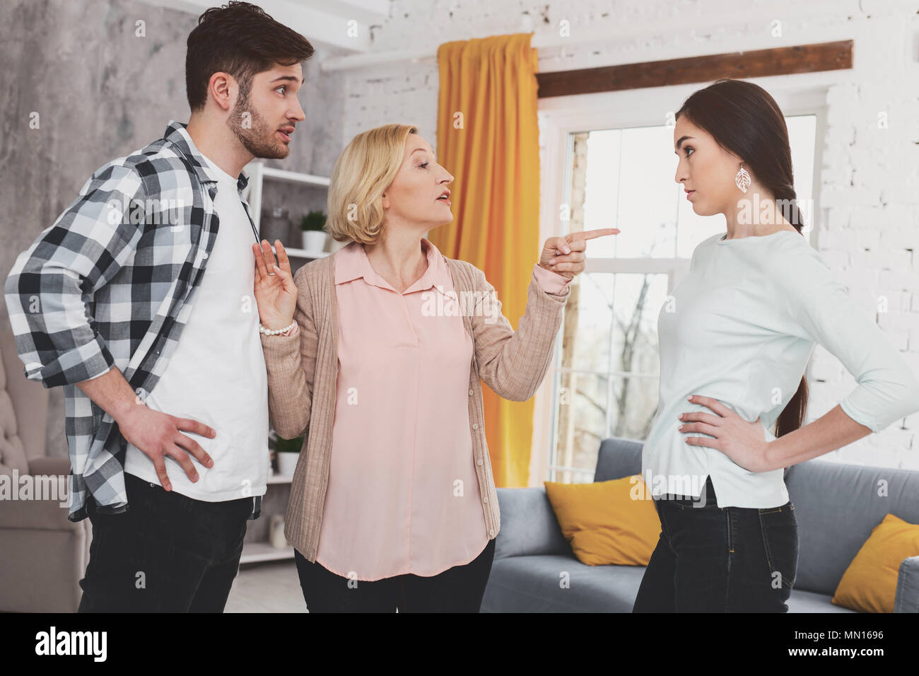 Gloomy aged woman defending her son Stock Photo - Alamy
